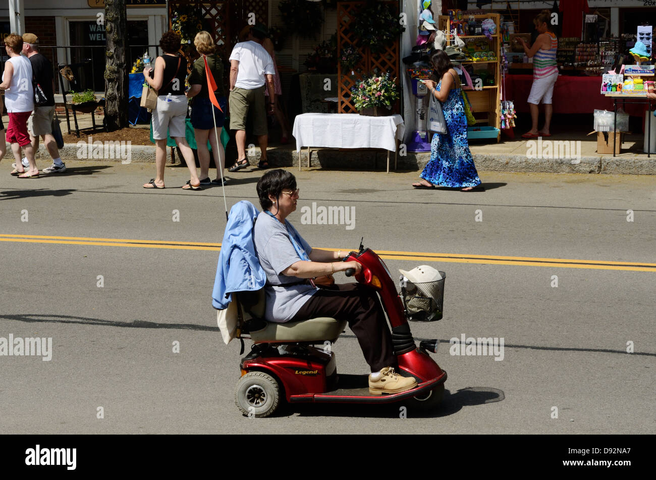 Fair goers stroll along street of small town fair Stock Photo - Alamy