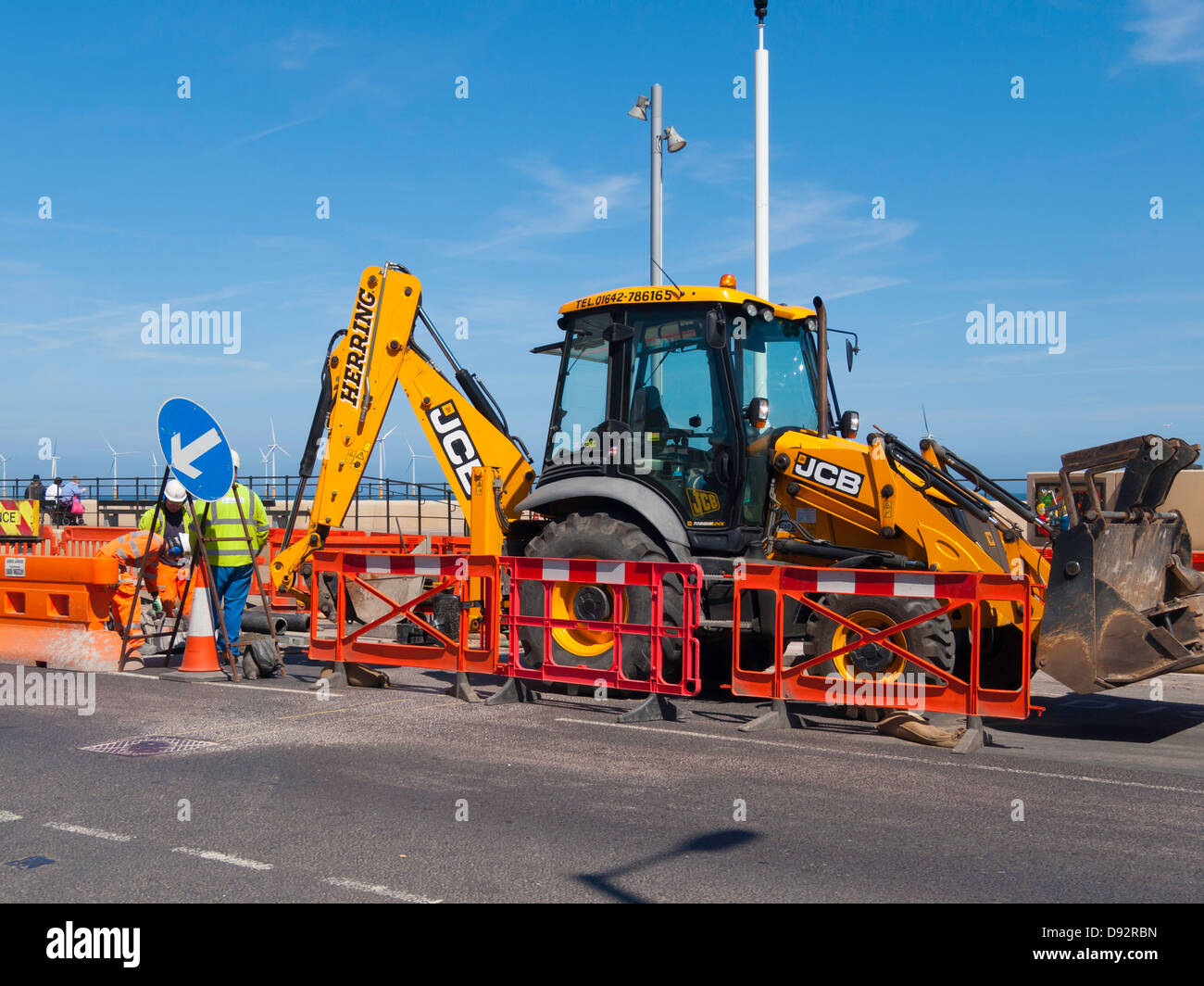 Road repairs by the local authority in progress using a JCB excavator ...