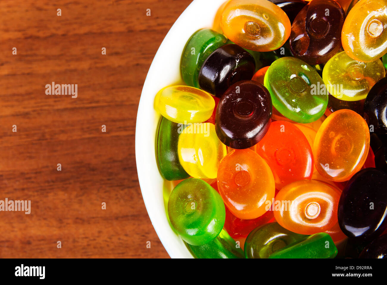 Candies in bowl on wooden table Stock Photo - Alamy
