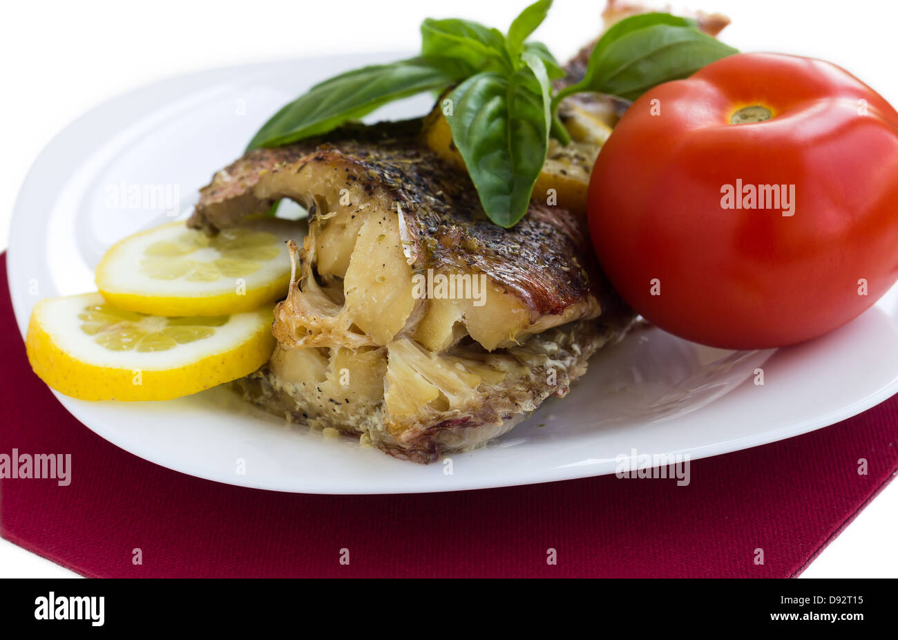 Served grilled fish with lemon and basil with tomato macro Stock Photo ...