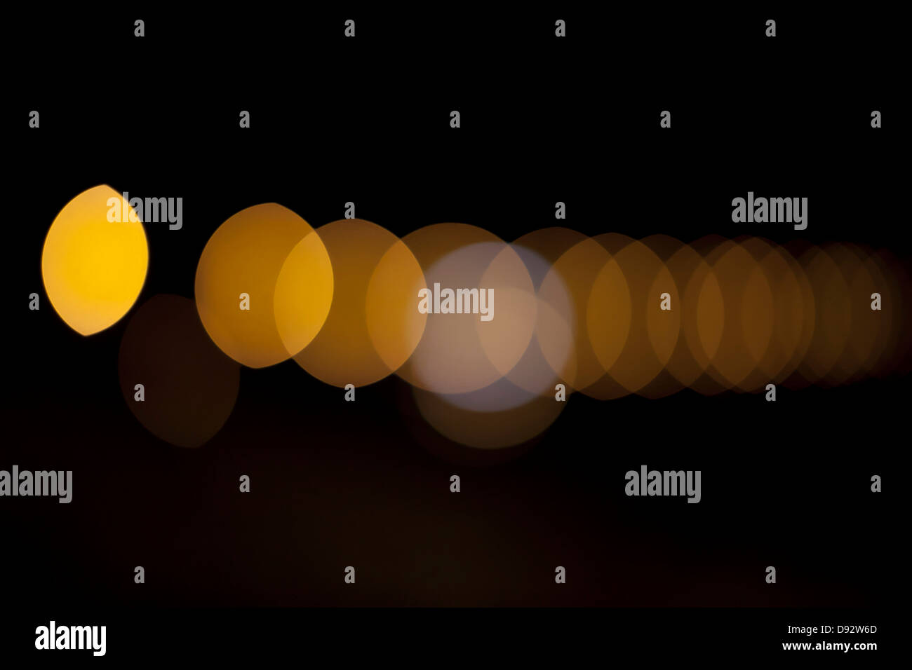 Orange circular light pattern against a black background Stock Photo ...