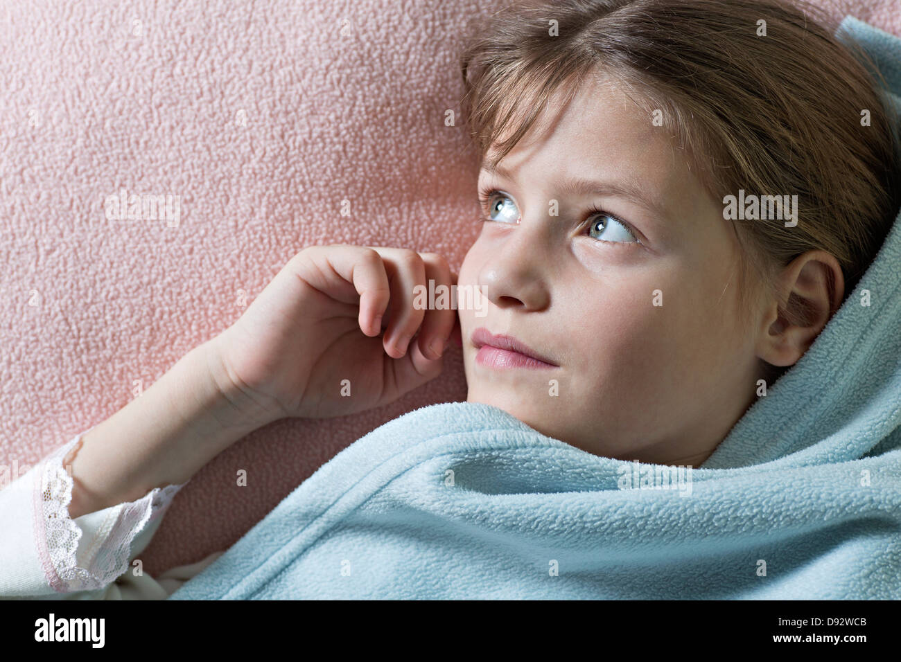 Daydreaming girl under blanket Stock Photo - Alamy