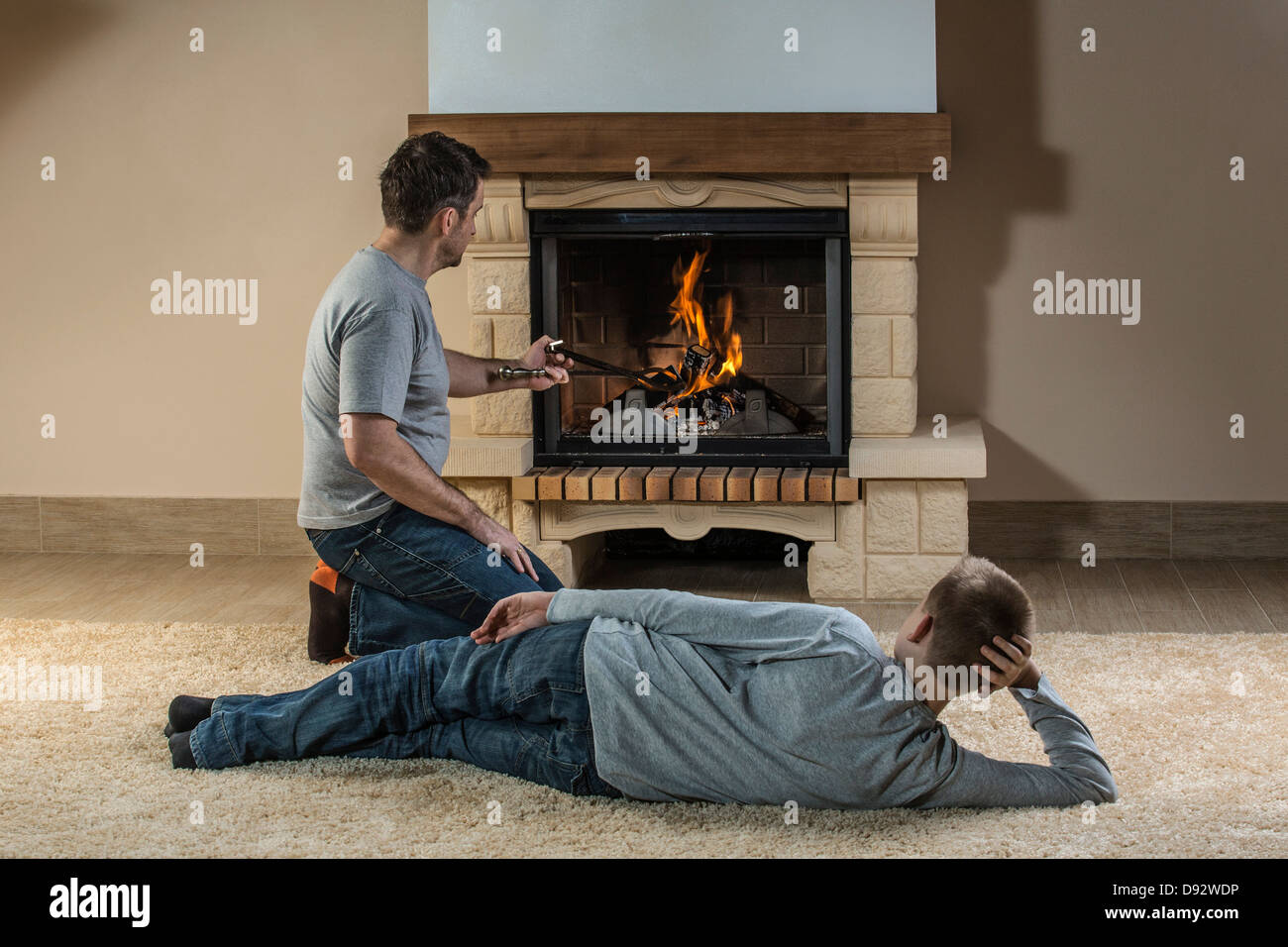 Father and son relaxing next to fire Stock Photo - Alamy
