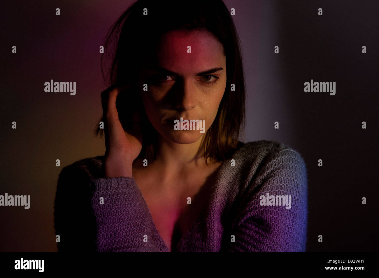 A woman looking suggestively into the camera while touching her hair ...