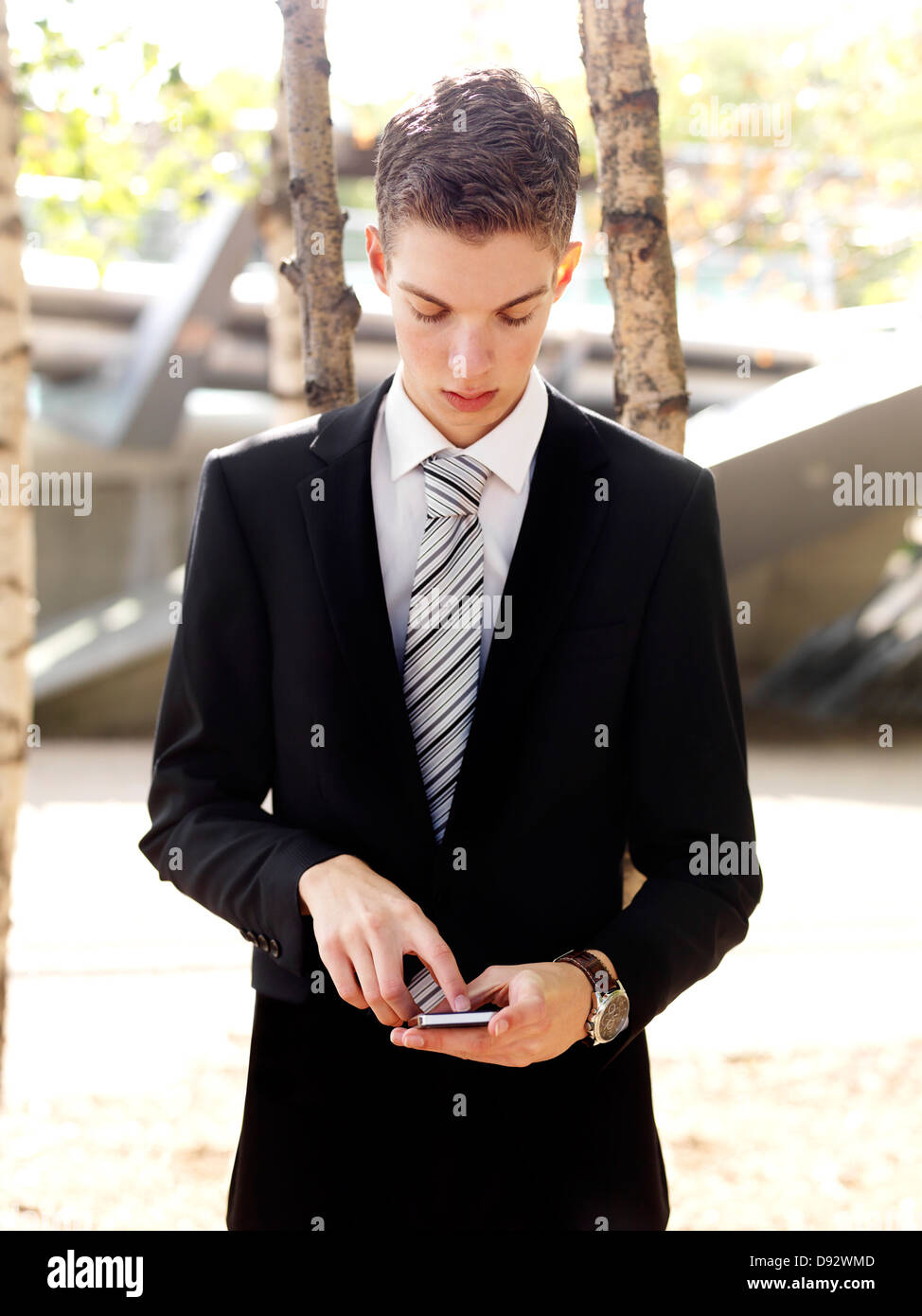 A serious young businessman text messaging on his smart phone Stock ...