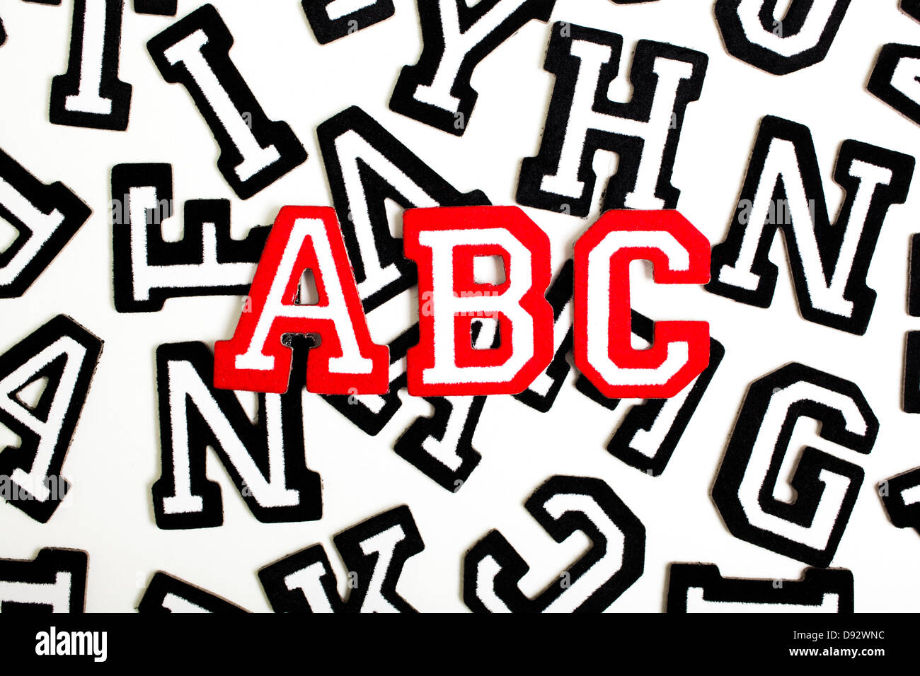 Red outlined varsity font stickers spelling ABC on top of black ...