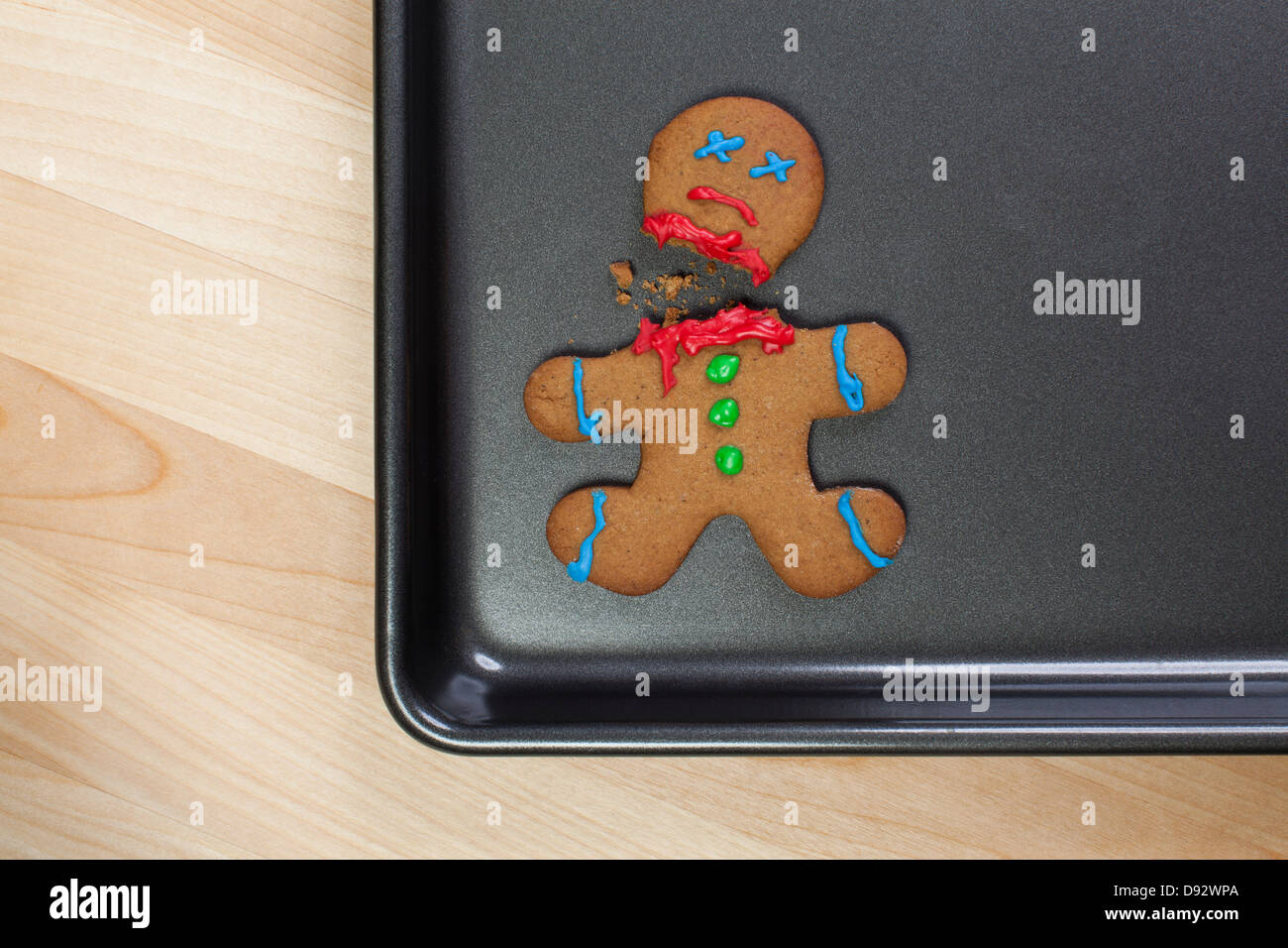 A decapitated gingerbread man on a baking sheet Stock Photo - Alamy