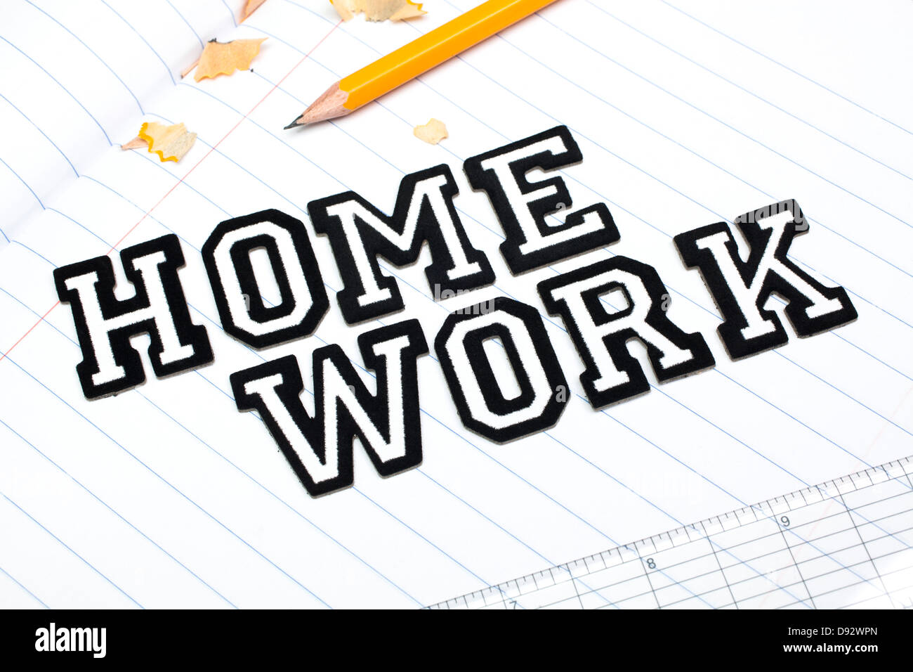 Varsity font stickers spelling out Homework atop a lined paper notebook ...