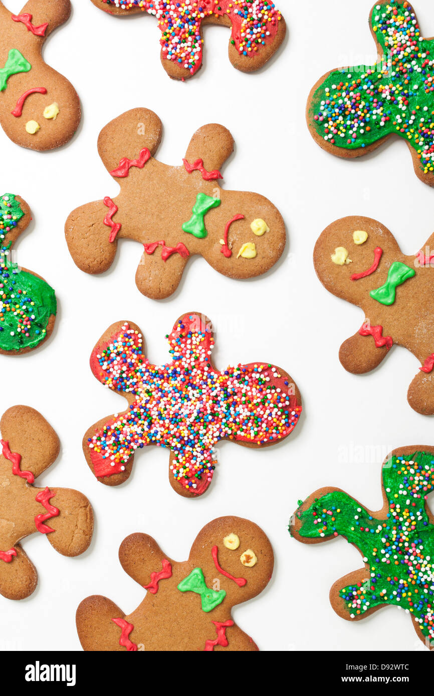 Various decorated gingerbread men cookies arranged on a white ...