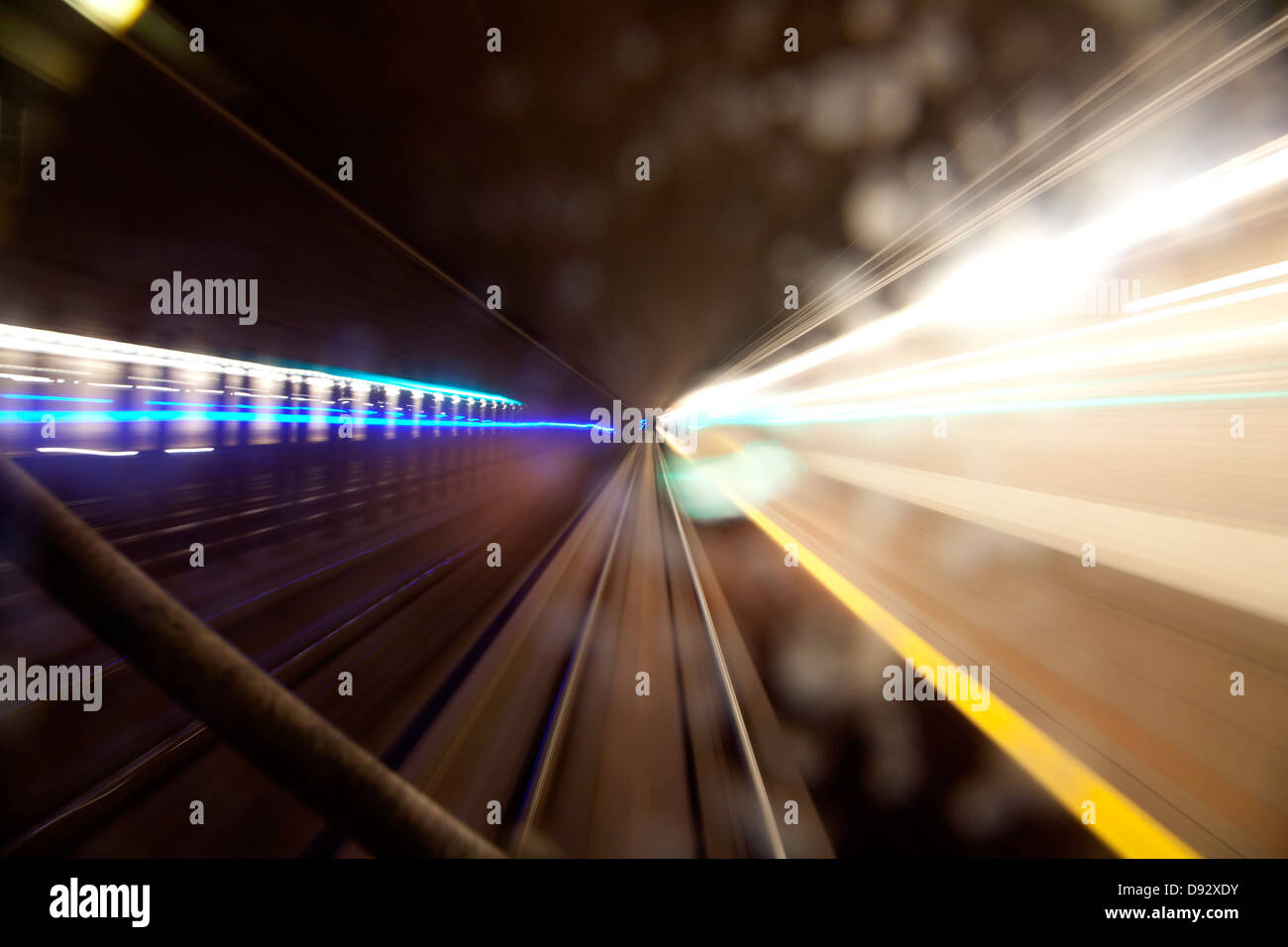 A subway platform viewed through the window of a departing subway train ...