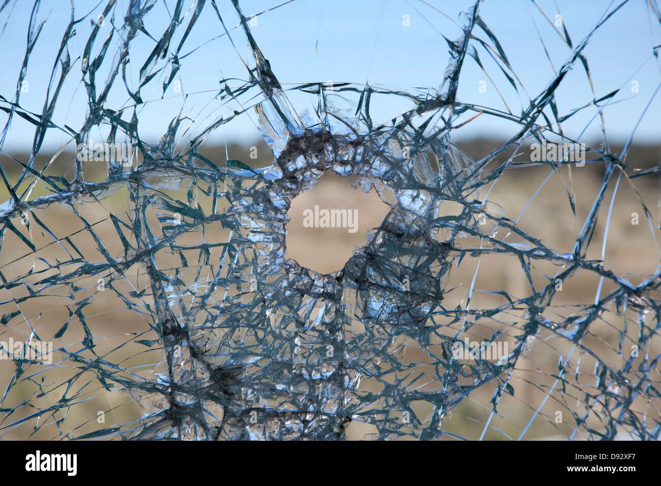 A broken glass window with hole in it Stock Photo - Alamy