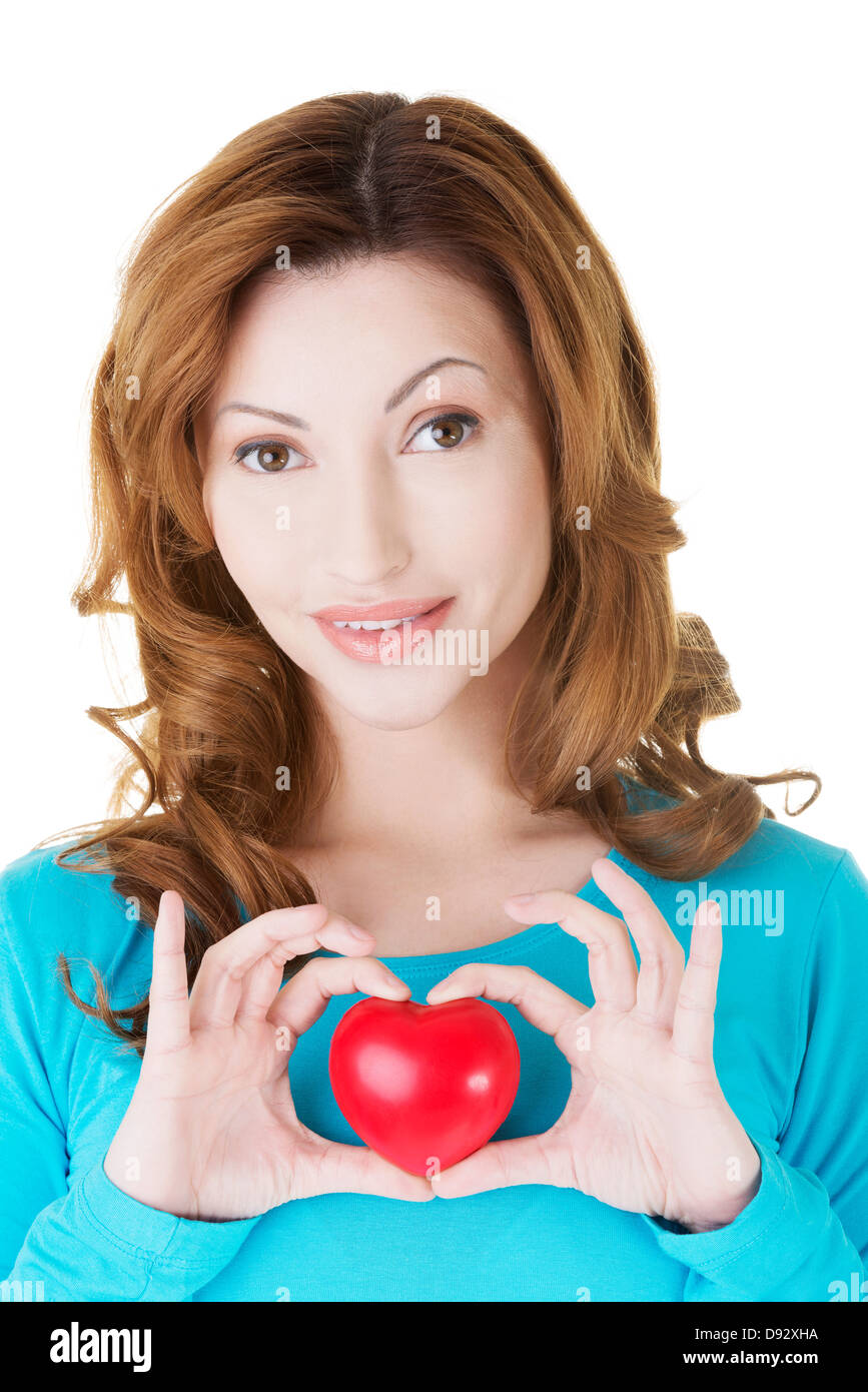 Attractive smiling woman showing red heart toy Stock Photo - Alamy