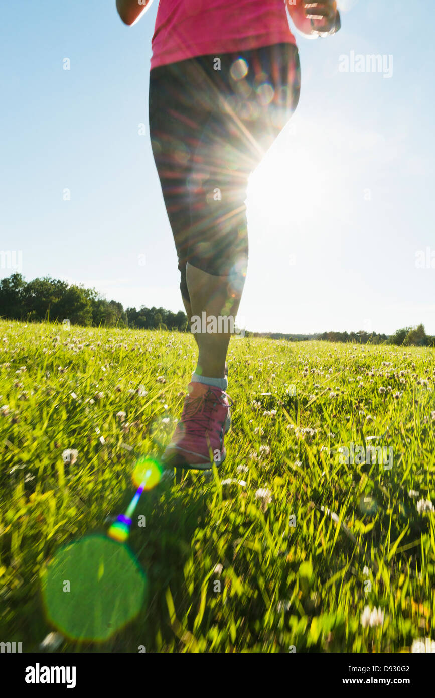 Low section of woman jogging in meadow Stock Photo - Alamy