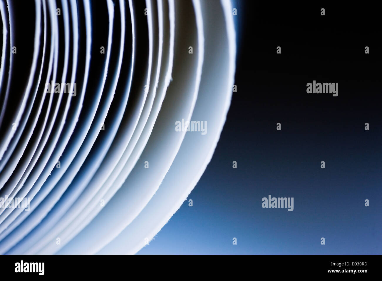 Close-up of bend paper on blue background Stock Photo - Alamy