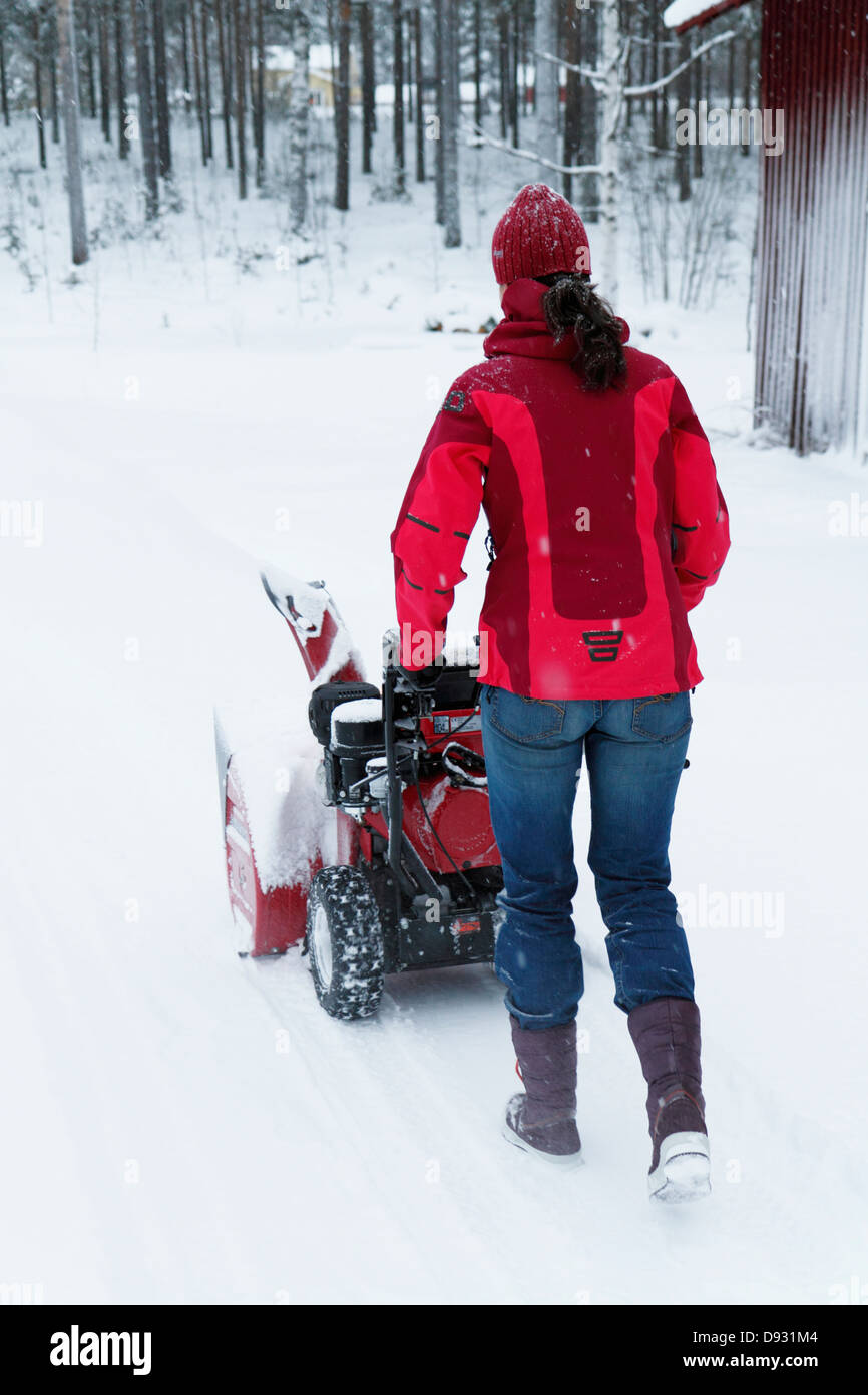 Woman using snowblower Stock Photo - Alamy