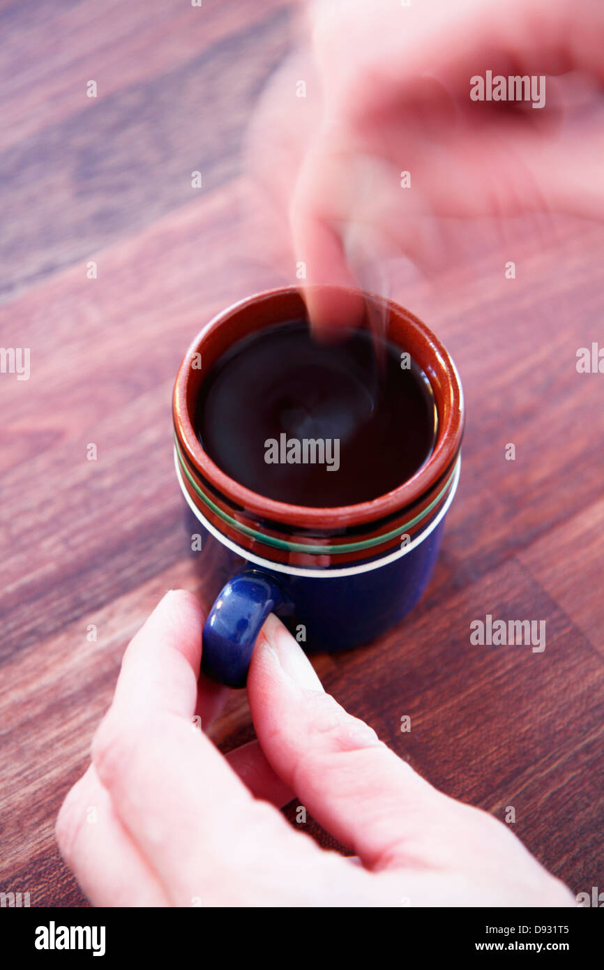 Woman stirring coffee Stock Photo - Alamy