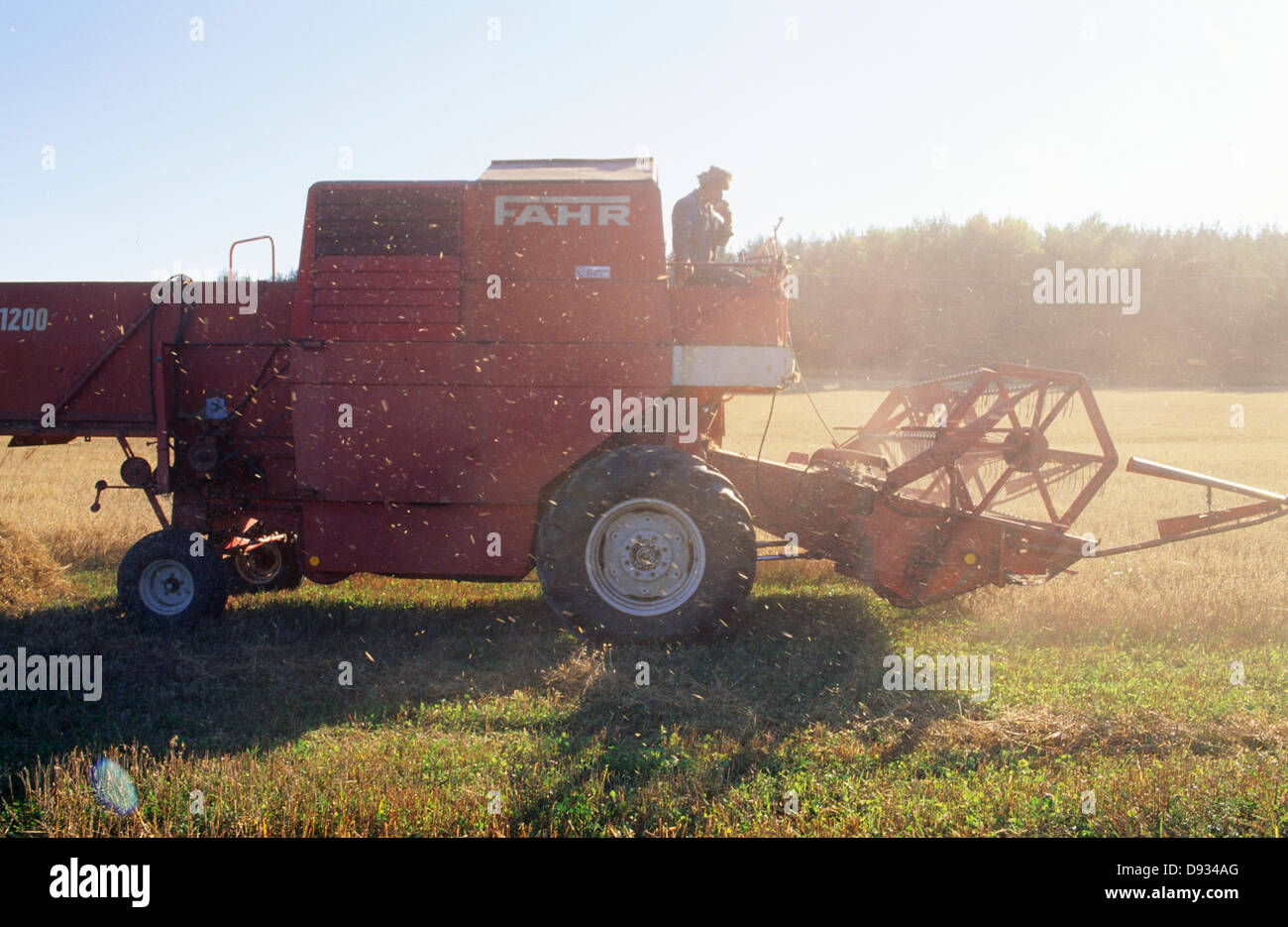 Man sitting on harvester, side view Stock Photo - Alamy