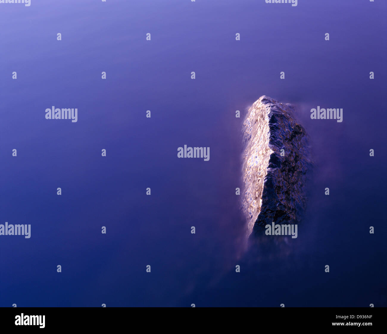Stone sticking out from the water Stock Photo - Alamy