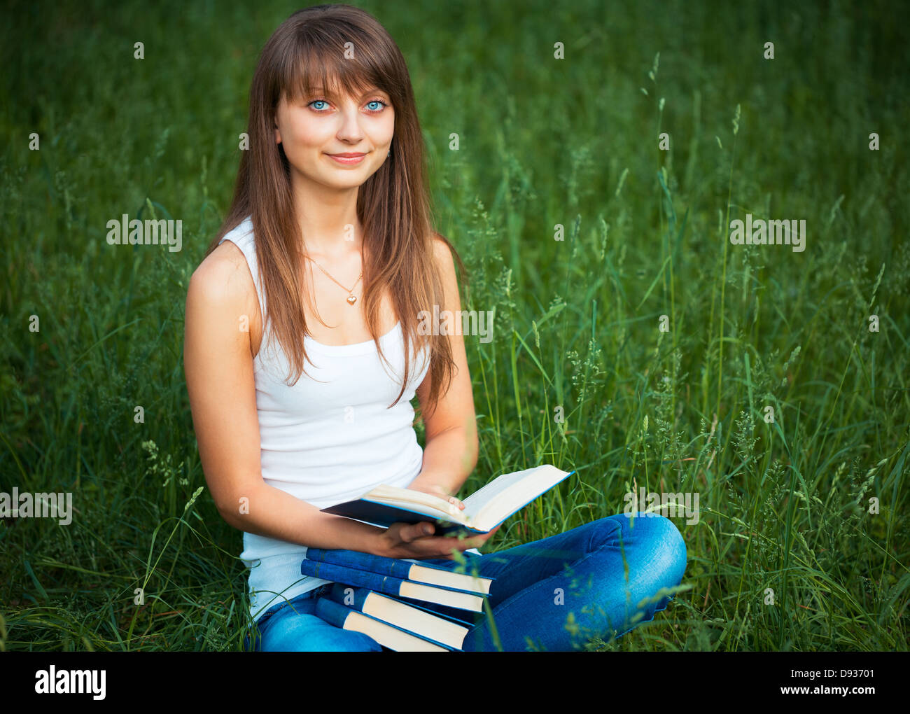 Beautiful girl with book in the park on green grass Stock Photo - Alamy