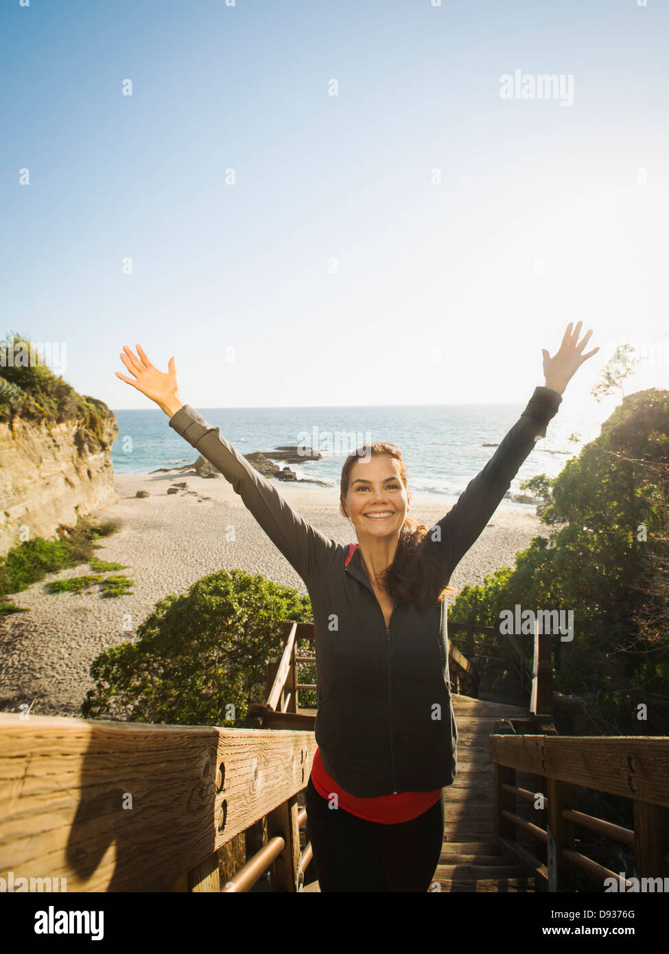 Mixed race woman climbing steps on beach Stock Photo - Alamy