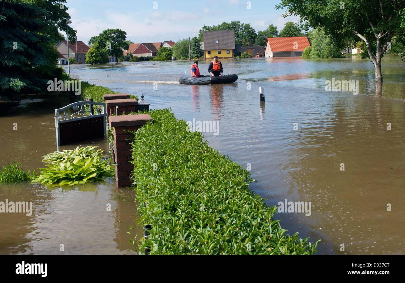 Fire fighters drive across flooded streets with a rubber boat in the ...