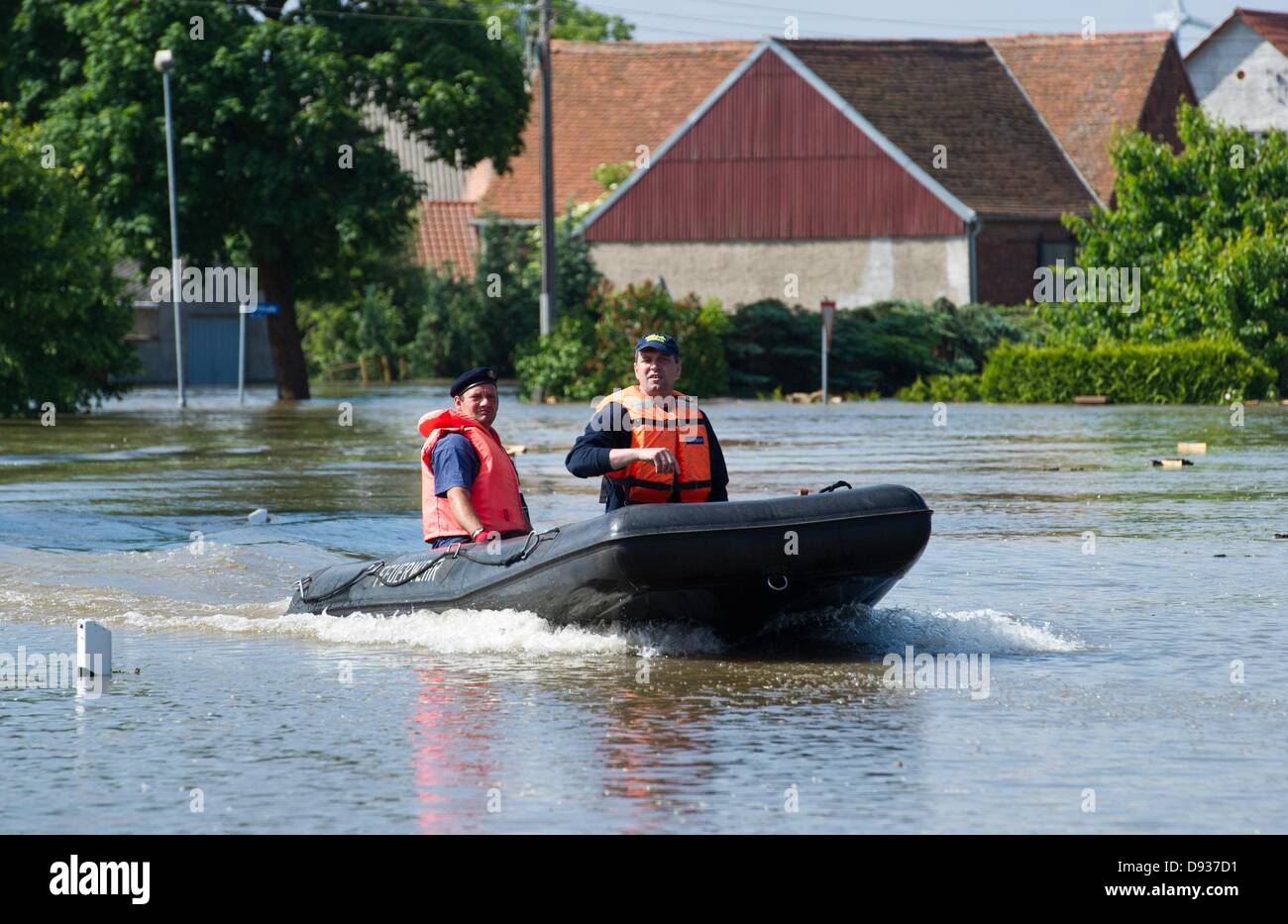 Fire fighters drive across flooded streets with a rubber boat in the ...