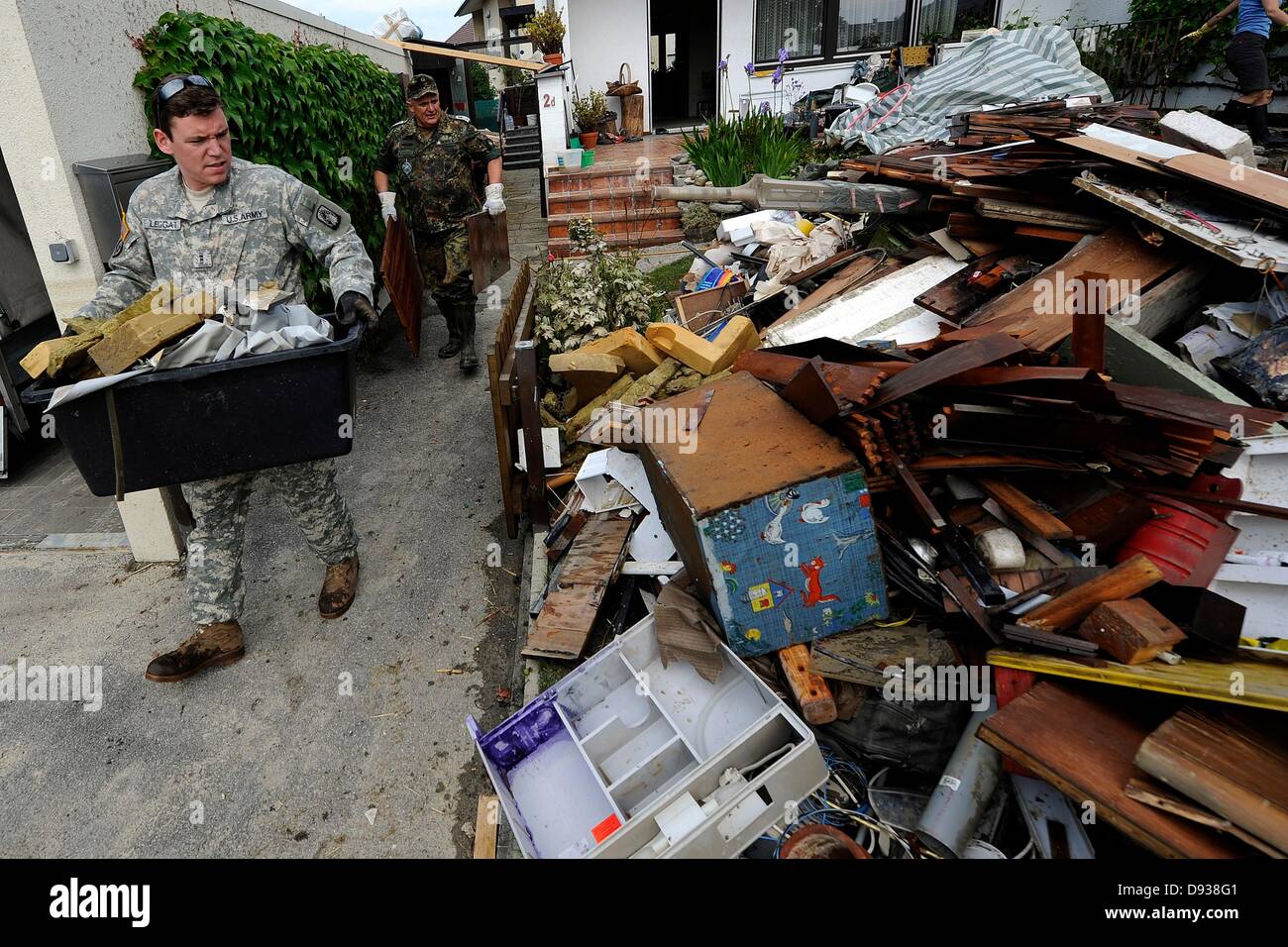 Soldiers of the US Army and the Bundeswehr help to clear out a basement ...