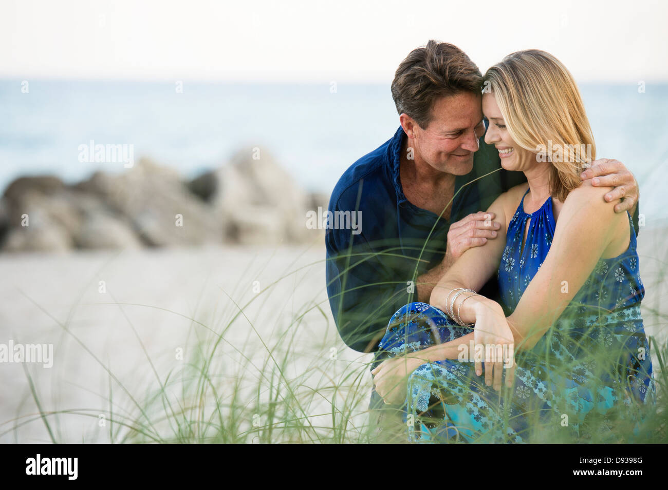 Couple smiling together on beach Stock Photo - Alamy