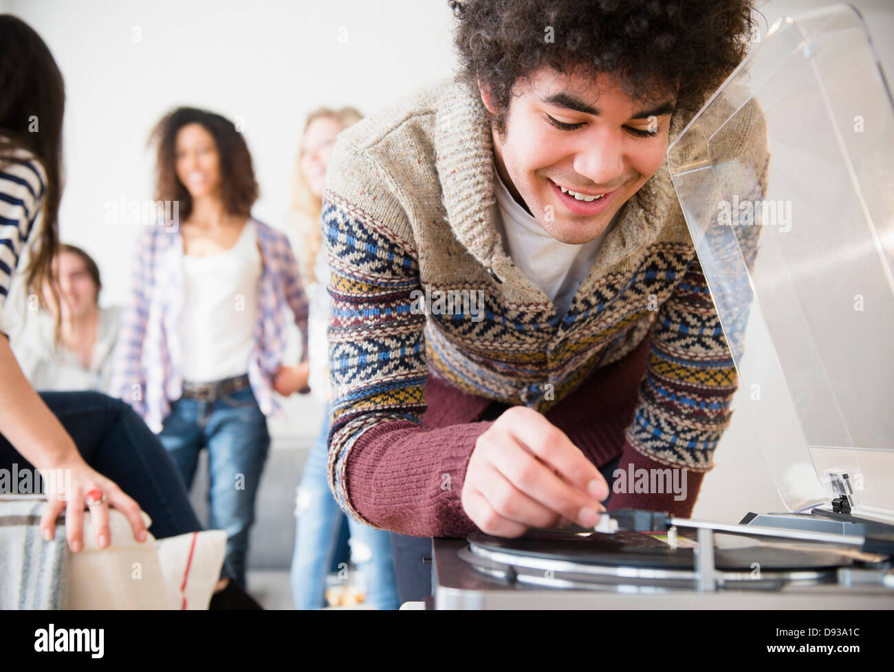 Man putting on record in living room Stock Photo - Alamy