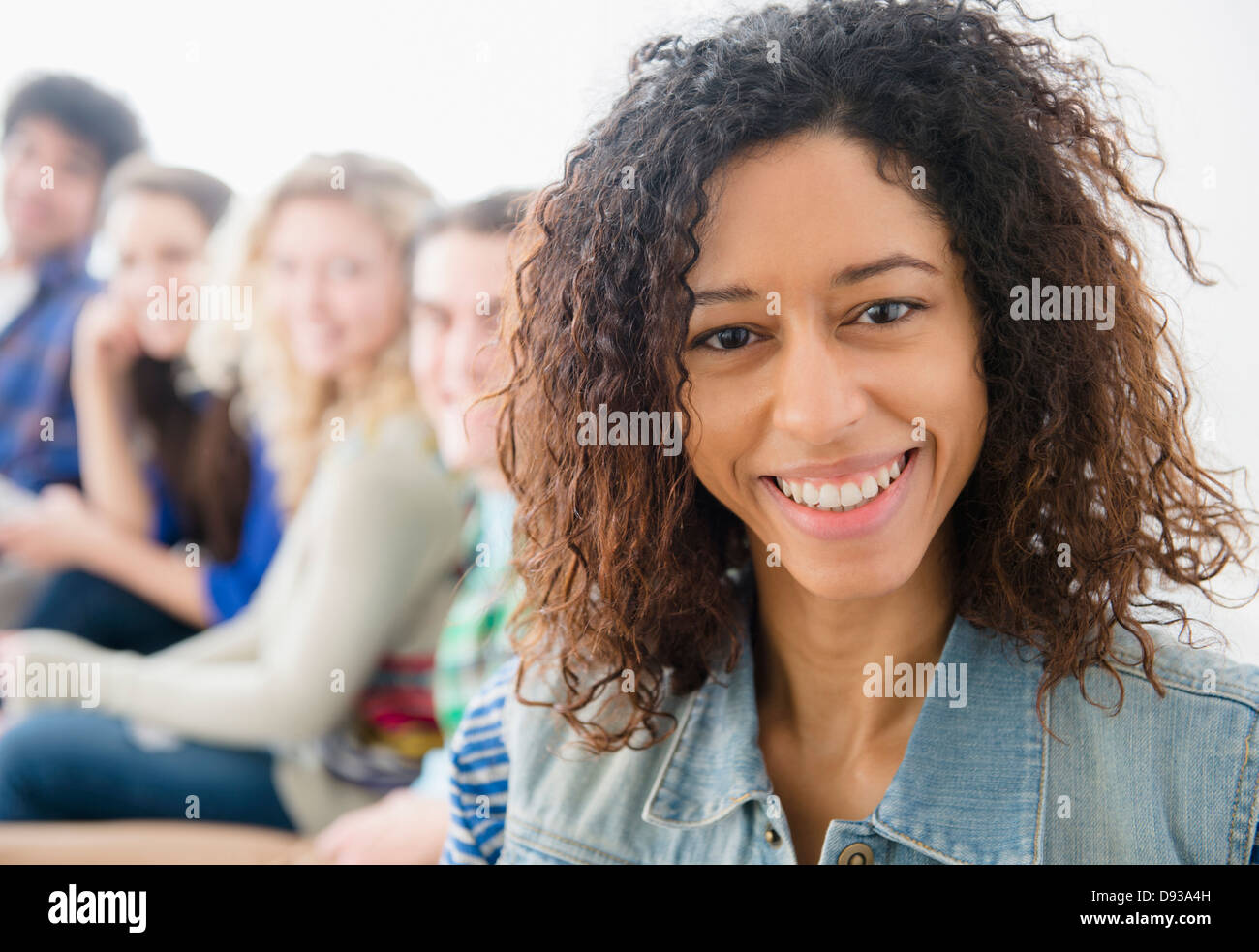 Smiling woman sitting on sofa Stock Photo - Alamy