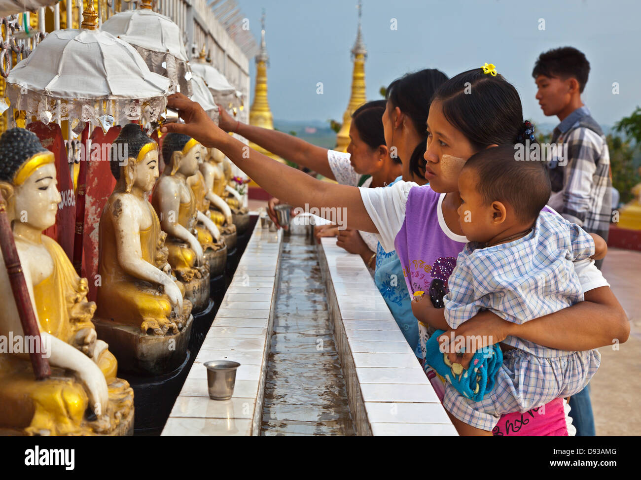 Making water offerings at a BUDDHIST TEMPLE in the town of PYIN U LWIN ...