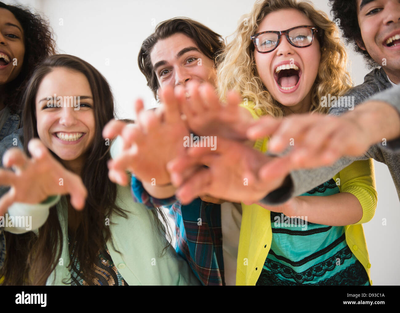 Friends reaching out together Stock Photo - Alamy