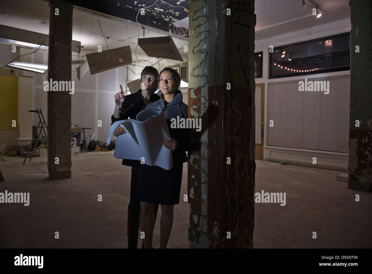 Business people reading blueprints in building Stock Photo - Alamy