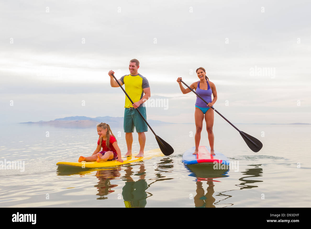 Family riding paddle boards Stock Photo - Alamy