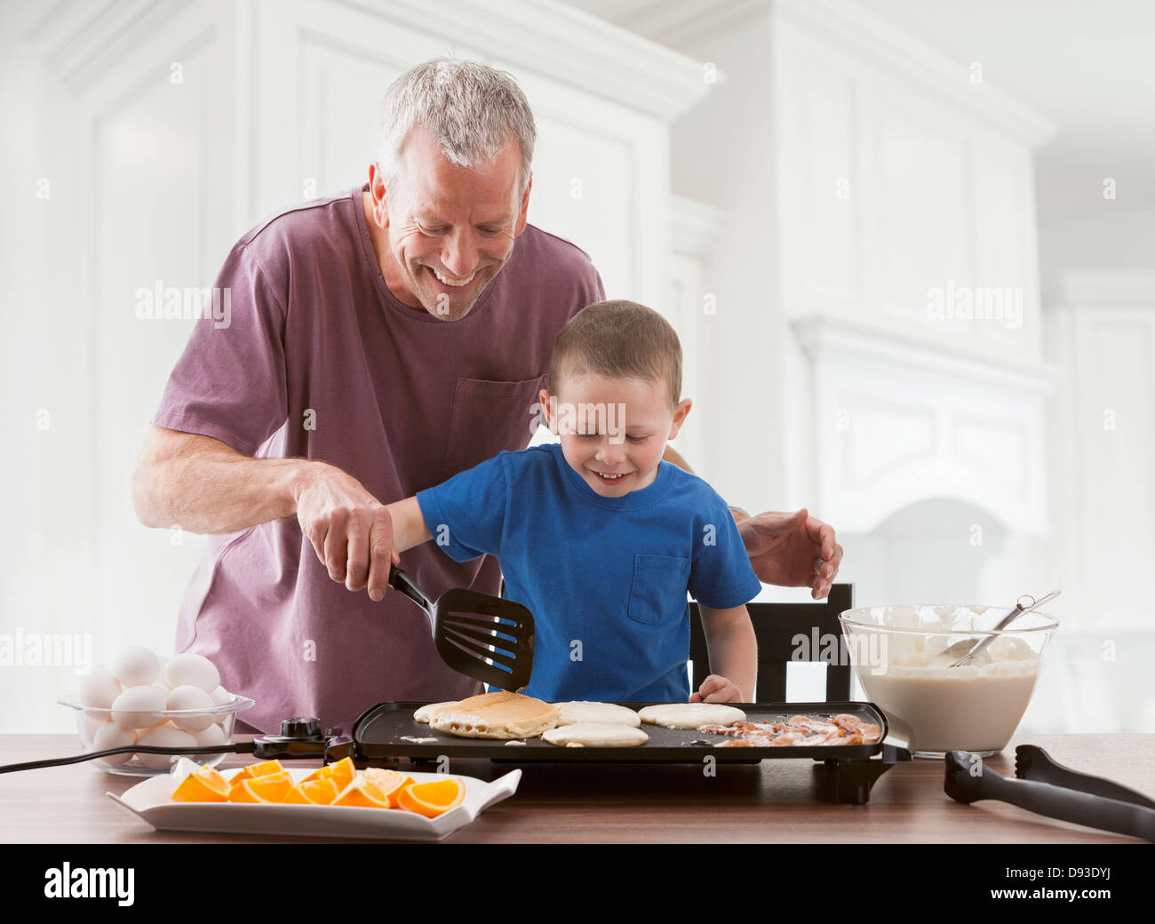 Caucasian father and son cooking breakfast Stock Photo - Alamy