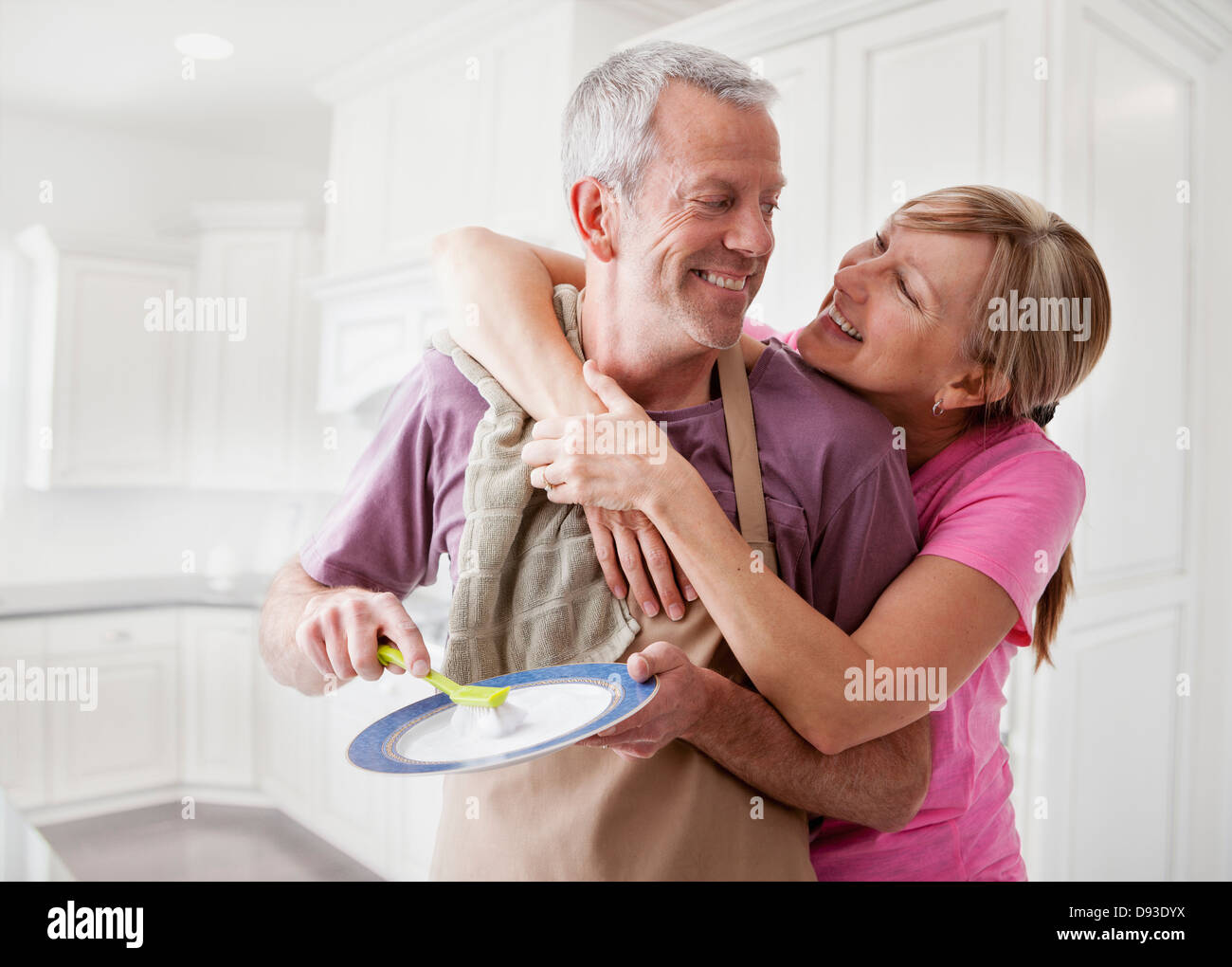 Woman washing dishes man hugging hi-res stock photography and images ...