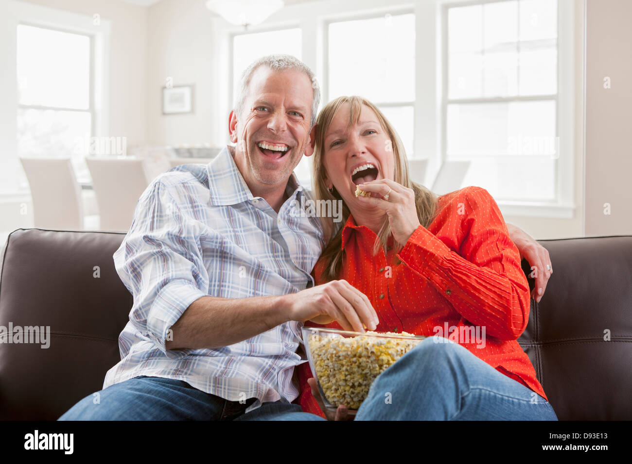 Caucasian couple eating popcorn on sofa Stock Photo - Alamy