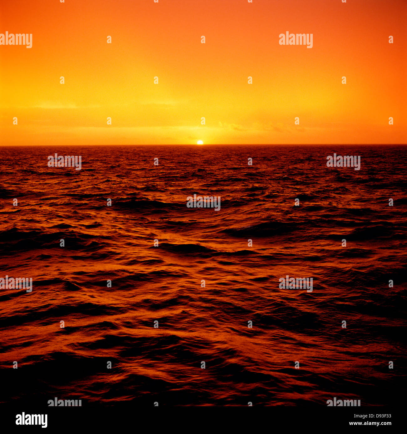 Sun setting on horizon of ocean Stock Photo - Alamy