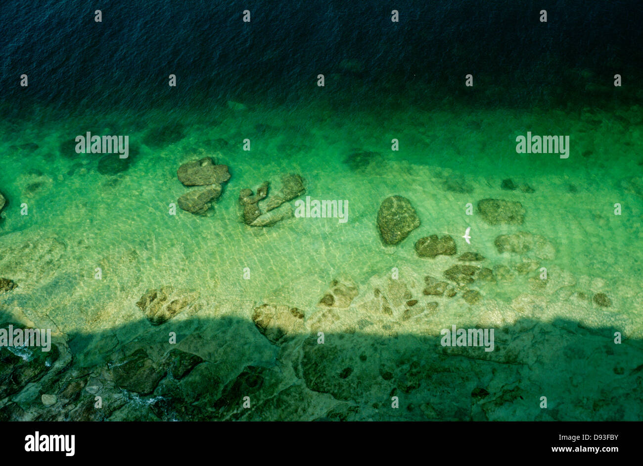 Rocks visible in shallow water Stock Photo - Alamy