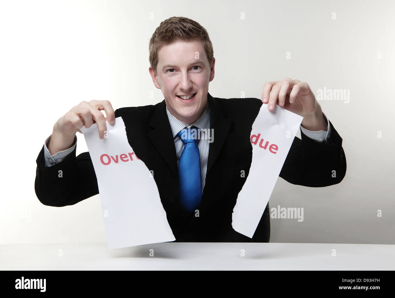 man in a suit sat at a desk ripping a piece of paper up with the words ...