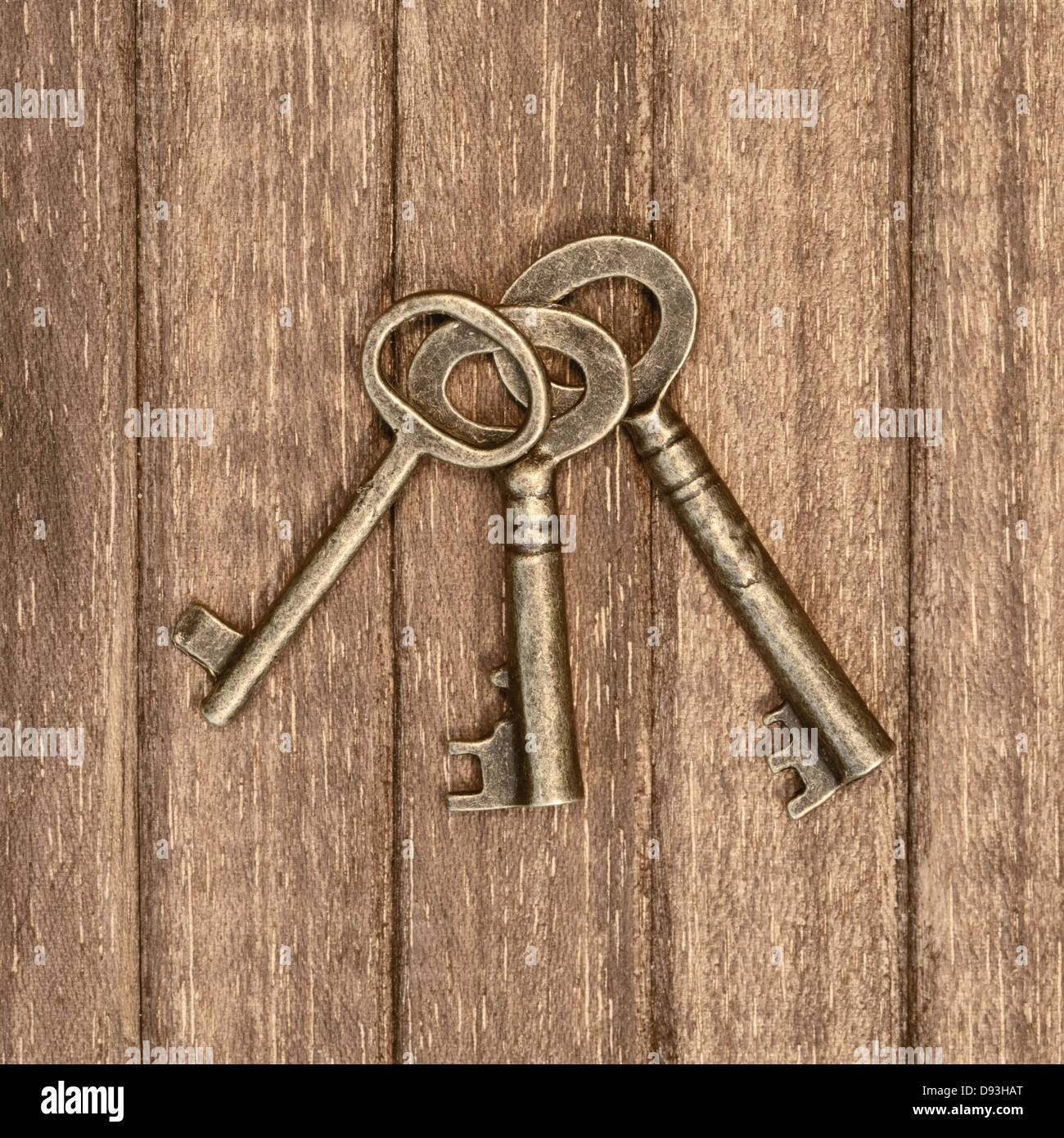 three old keys on a wooden background Stock Photo - Alamy