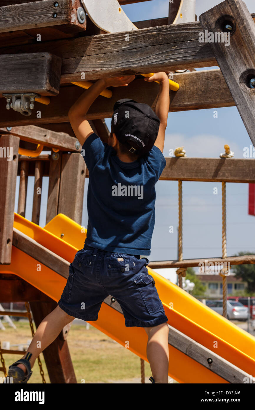 Little boy playing on monkey bars at the playground Stock Photo - Alamy