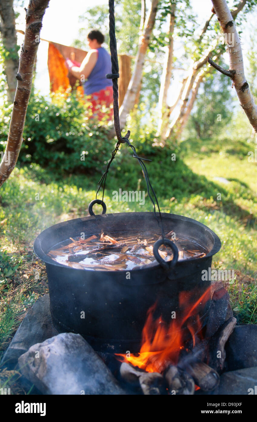 Vessel on fire with woman drying cloths in background Stock Photo - Alamy