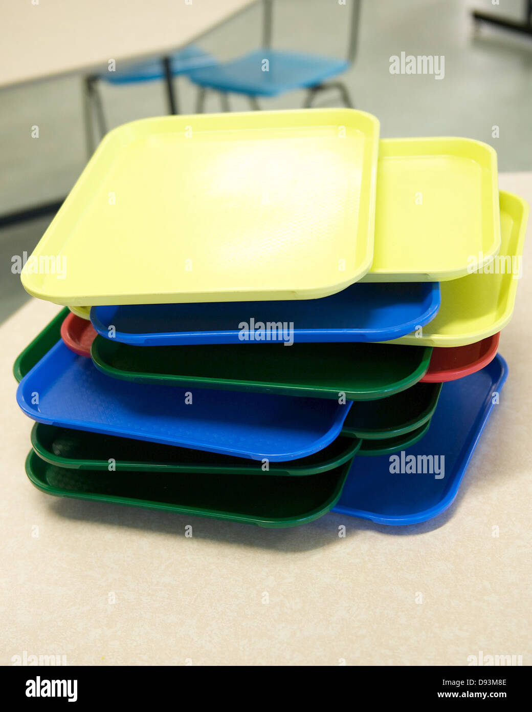A pile of coloured trays in a school canteen Stock Photo - Alamy