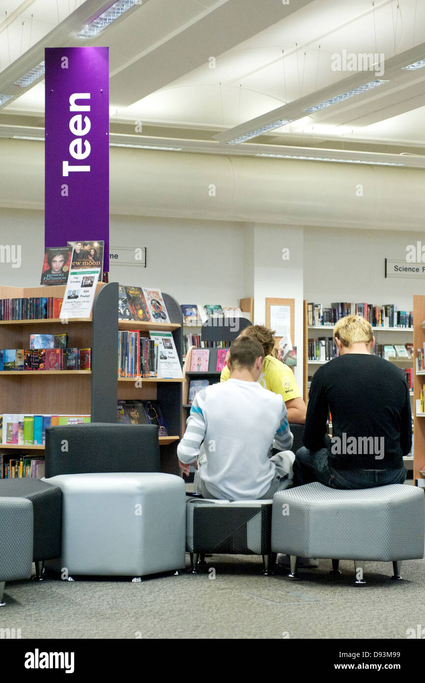 Three teenagers sit in the teen area of a public library Stock Photo ...