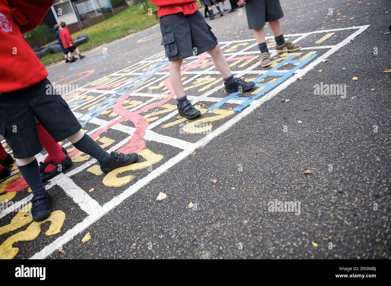Children playing on a numbered grid square on the playground of their ...