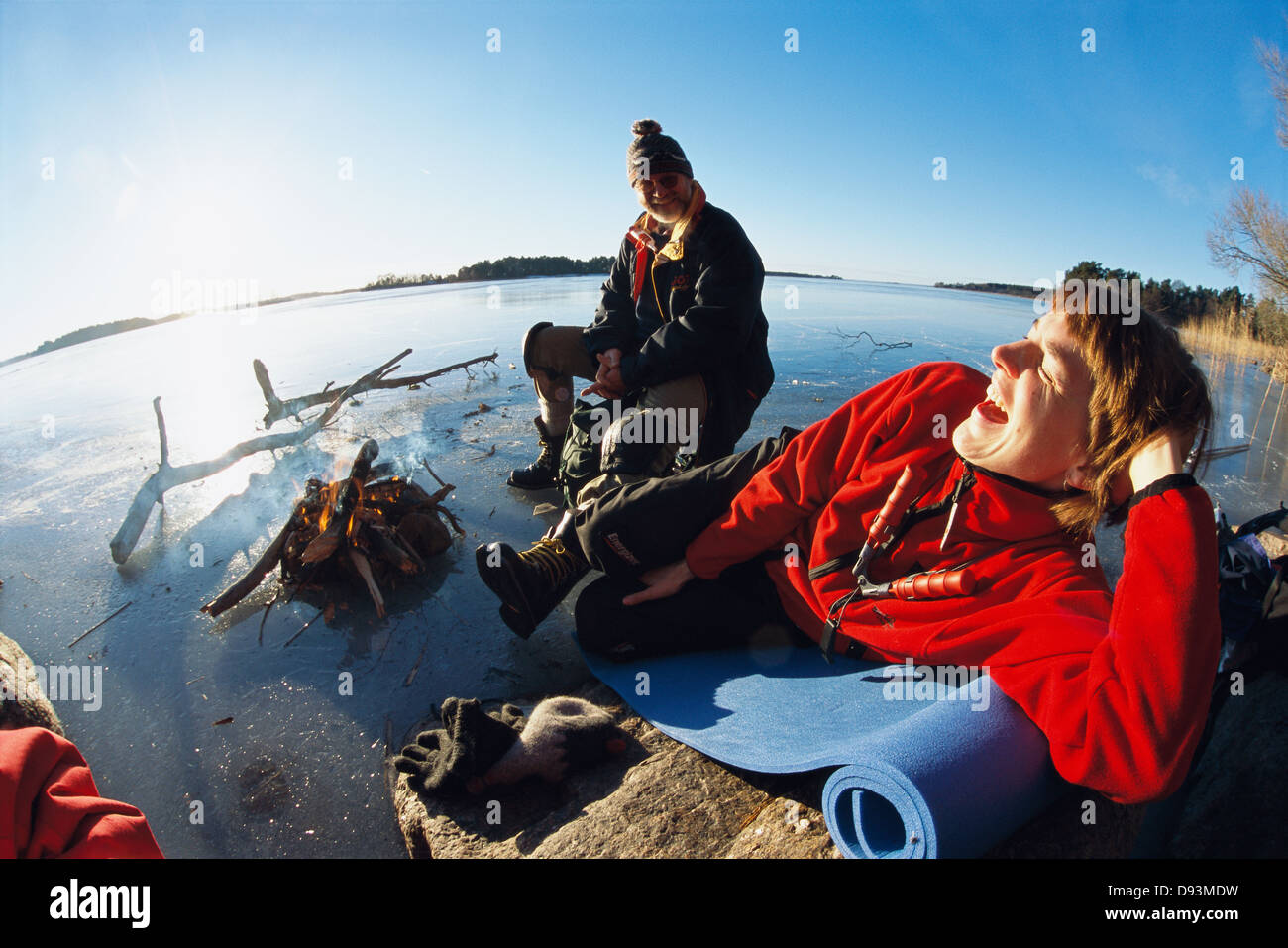 People sitting around bonfire Stock Photo - Alamy