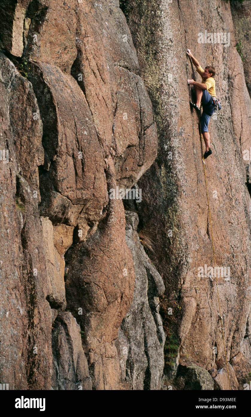 Mountaineer climbing mountain, side view Stock Photo - Alamy