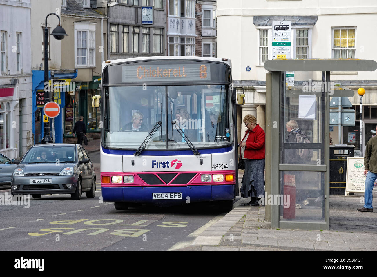 Passengers boarding a bus at a bus stop Weymouth Dorset England uk ...