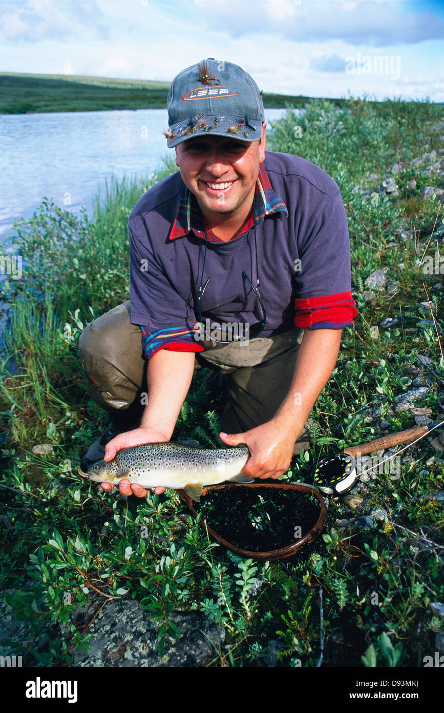 Man holding fish, smiling, portrait Stock Photo - Alamy